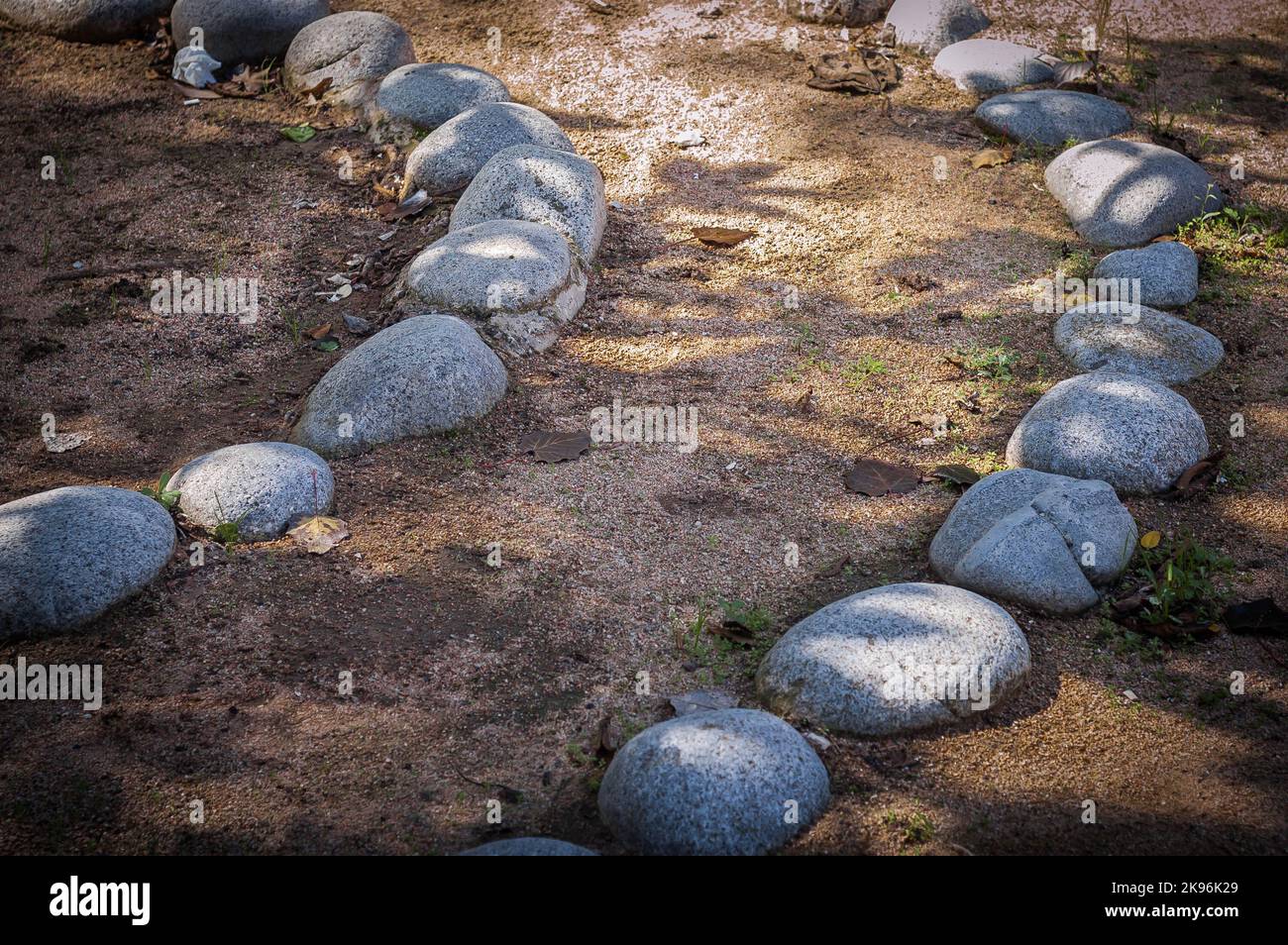 Curved path marked by stones of different sizes on both sides Stock ...