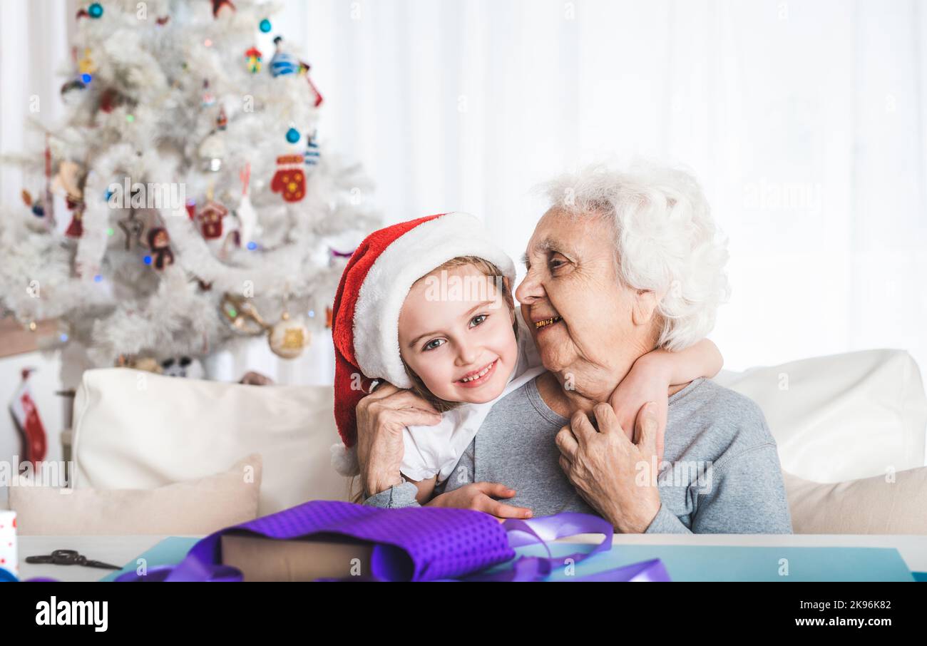 Granddaughter in sit hugging with grandma Stock Photo - Alamy