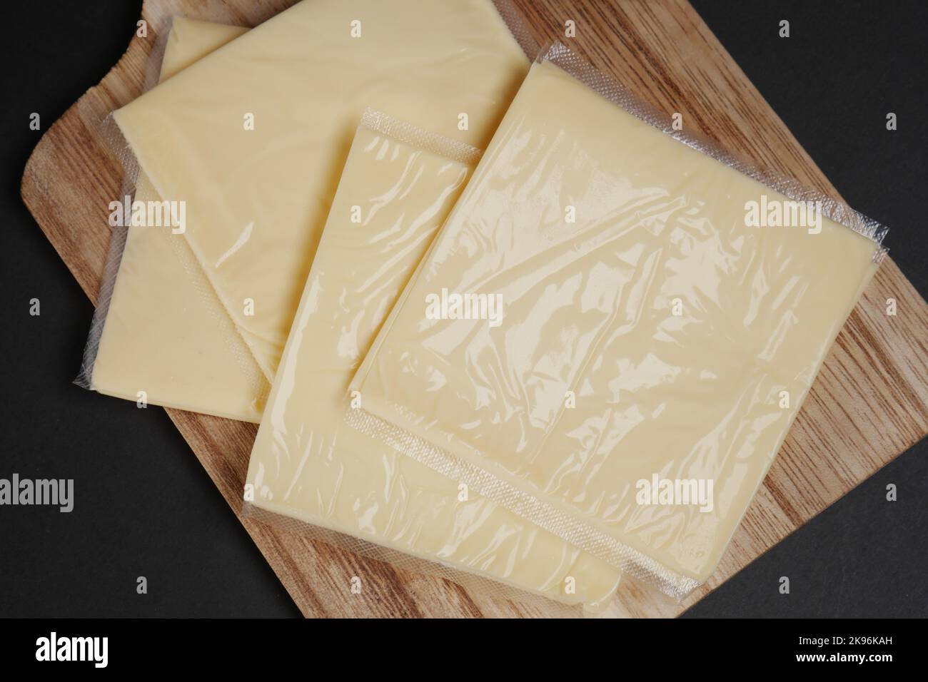 Transparent packet with slices of cheese on yellow Stock Photo - Alamy