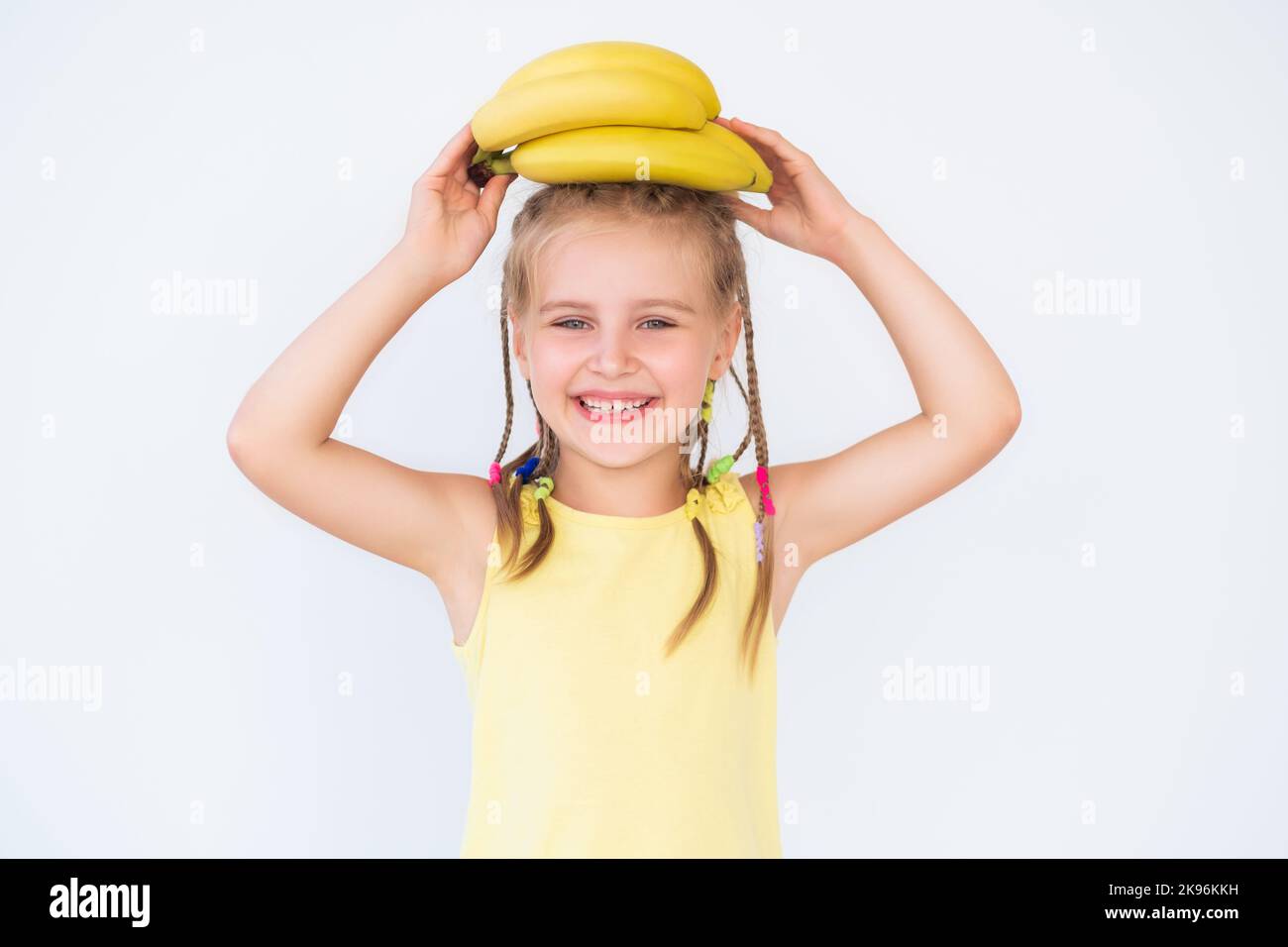 Kid girl with fine banana isolated on white Stock Photo - Alamy