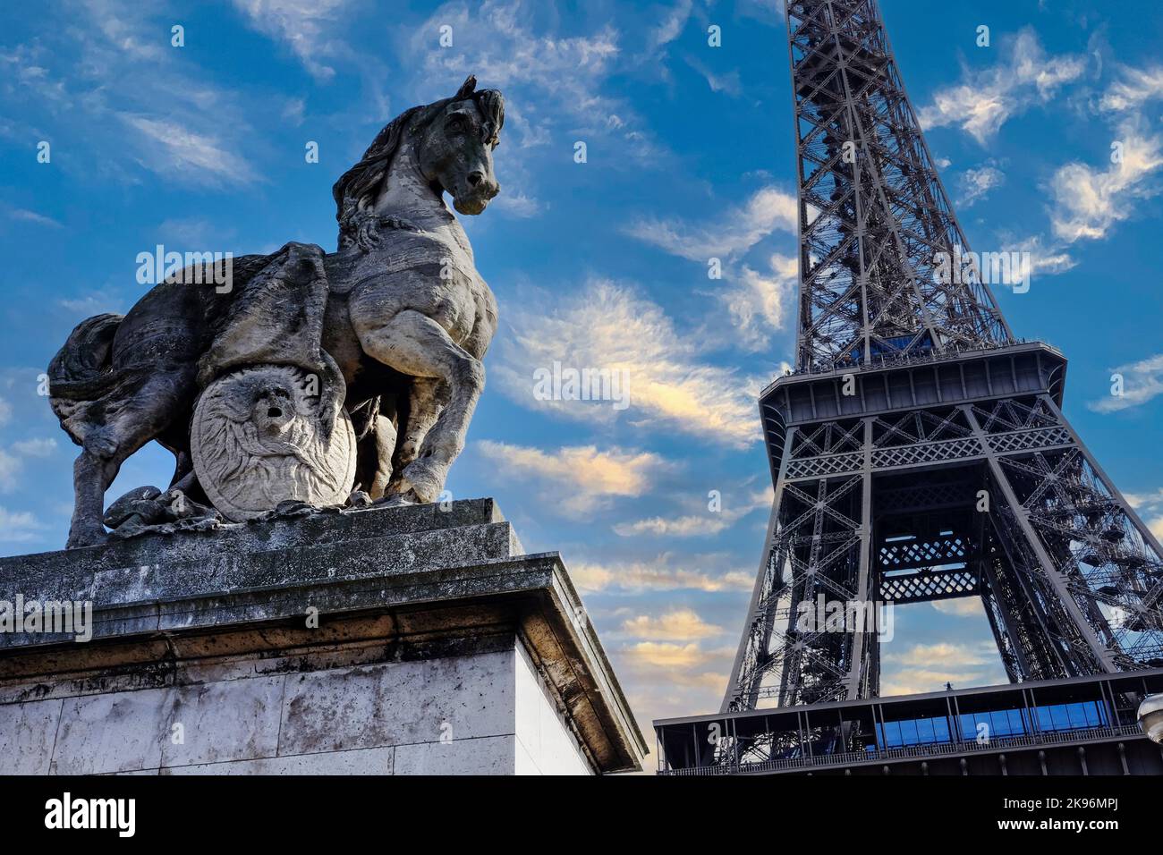 A sculpture of a majestic horse in Paris with the Eiffel Tower looming ...