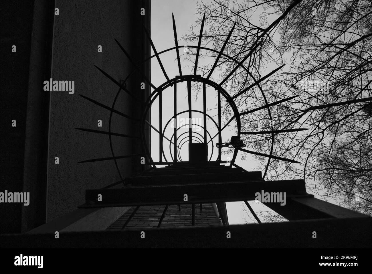 A grayscale shot of a metal frame with spikes on a building Stock Photo ...