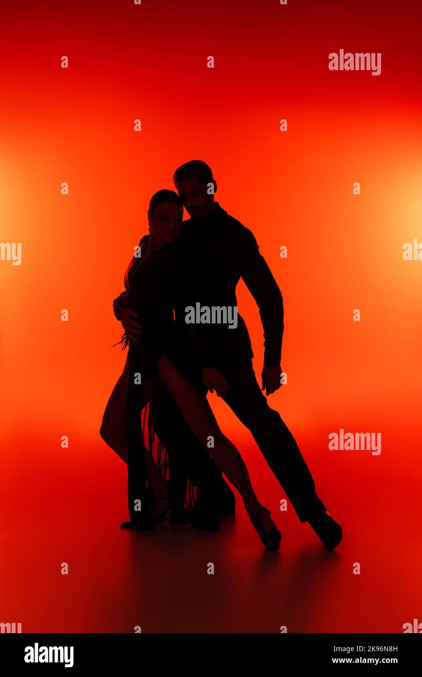 Silhouette of ballroom dancers performing tango on red background Stock ...