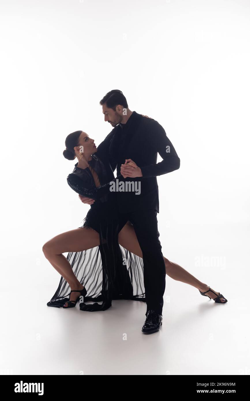 Side view of professional dancers holding hands while performing tango ...