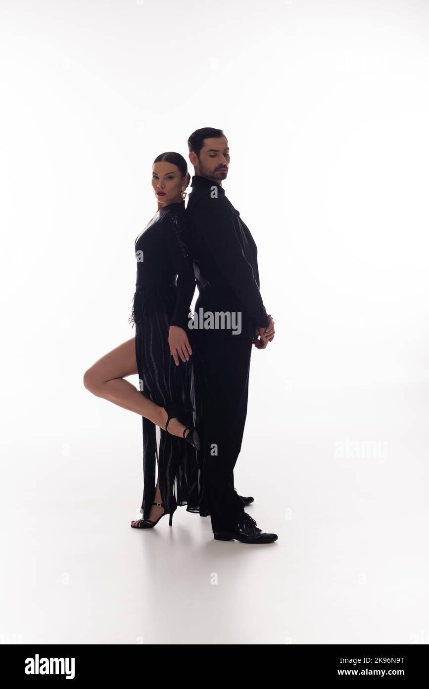 Pair of professional dancers standing back to back on white background ...