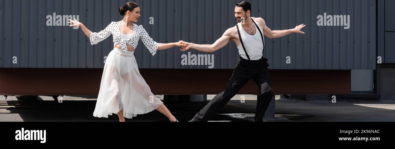 Pair of dancers performing choreography on roof of building, banner ...