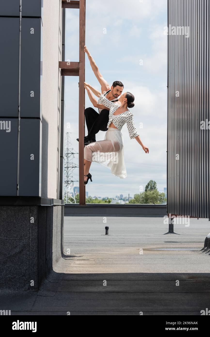 Professional ballroom dancers looking at each other while posing on ...