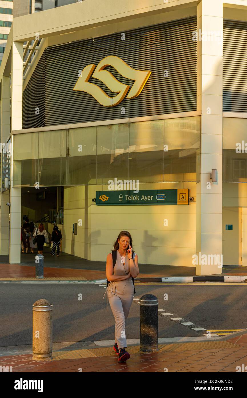 Telok Ayer MRT station at sunset with a passing pedestrian, Singapore ...