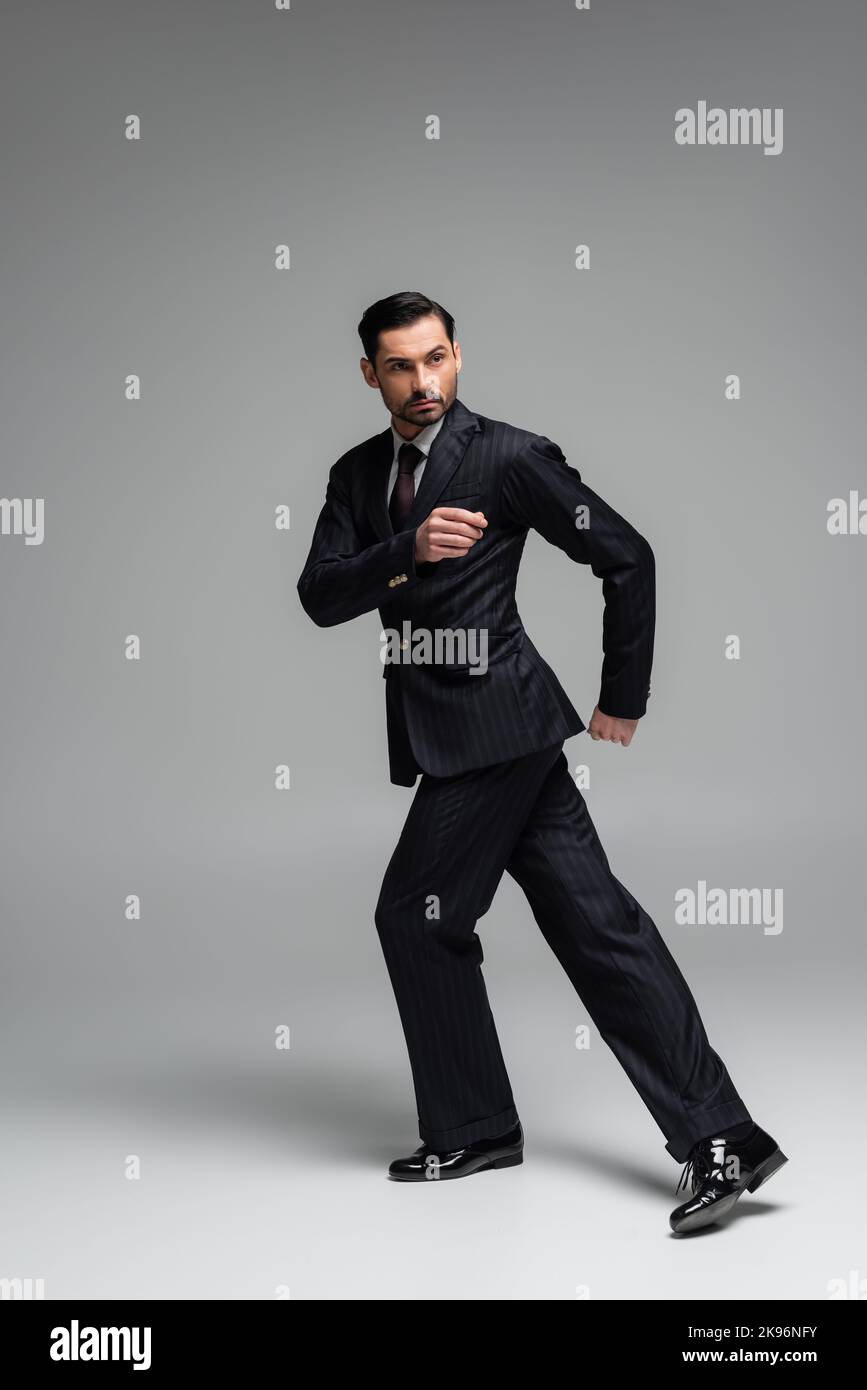 Full length of elegant ballroom dancer moving on grey background Stock ...