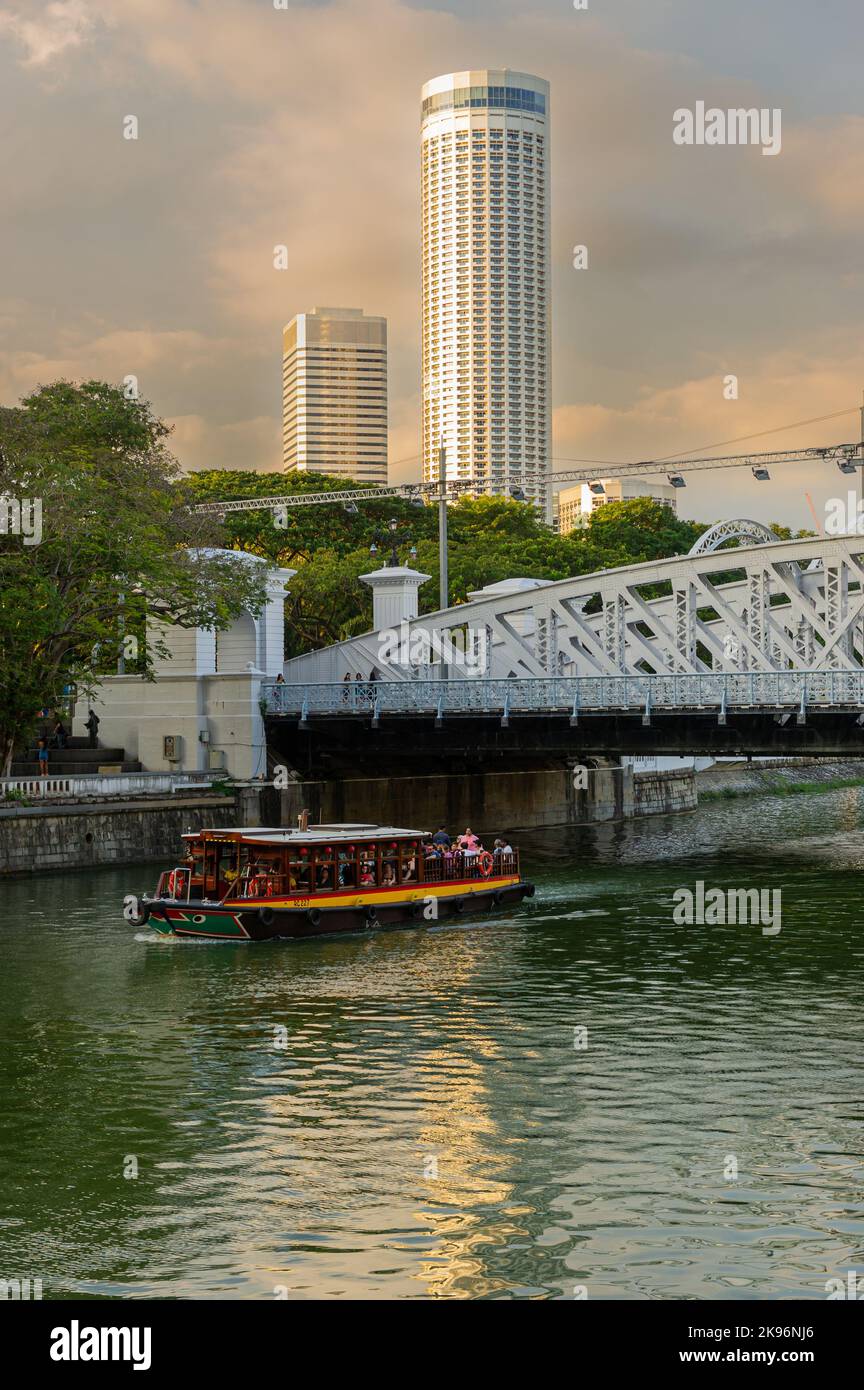 A tourist boat passing under the Anderson Bridge at sunset, Boat Quay ...