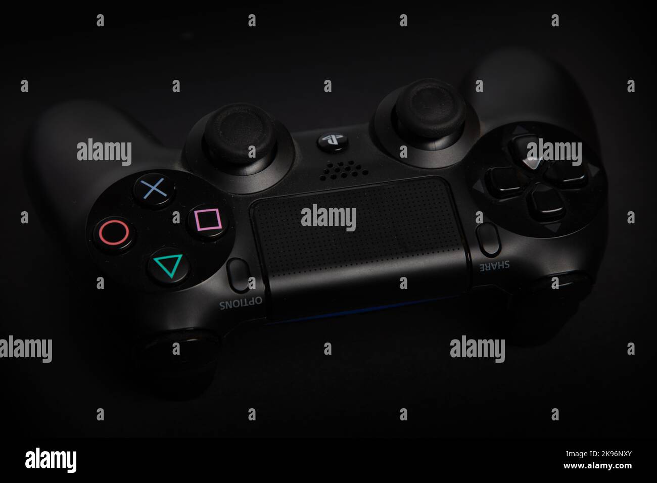 a detail shot of a playstation gaming joypad on a black, dark ...