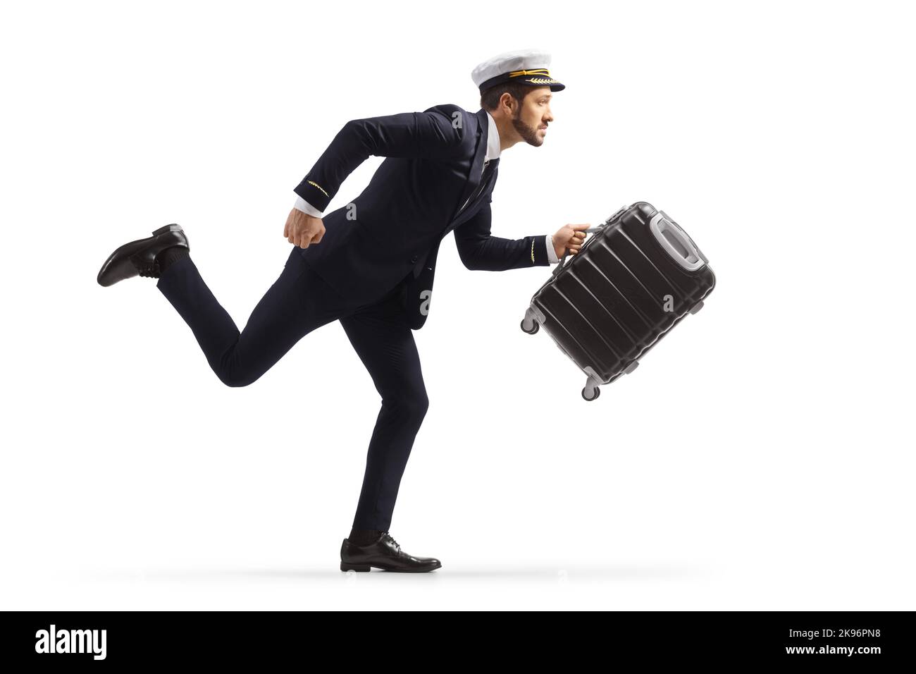 Full length profile shot of a pilot in a hurry carrying a suitcase and ...