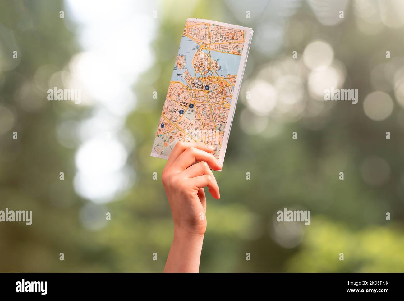 Sport orienteeing concept. Paper map, guide in hand on blurred forest ...