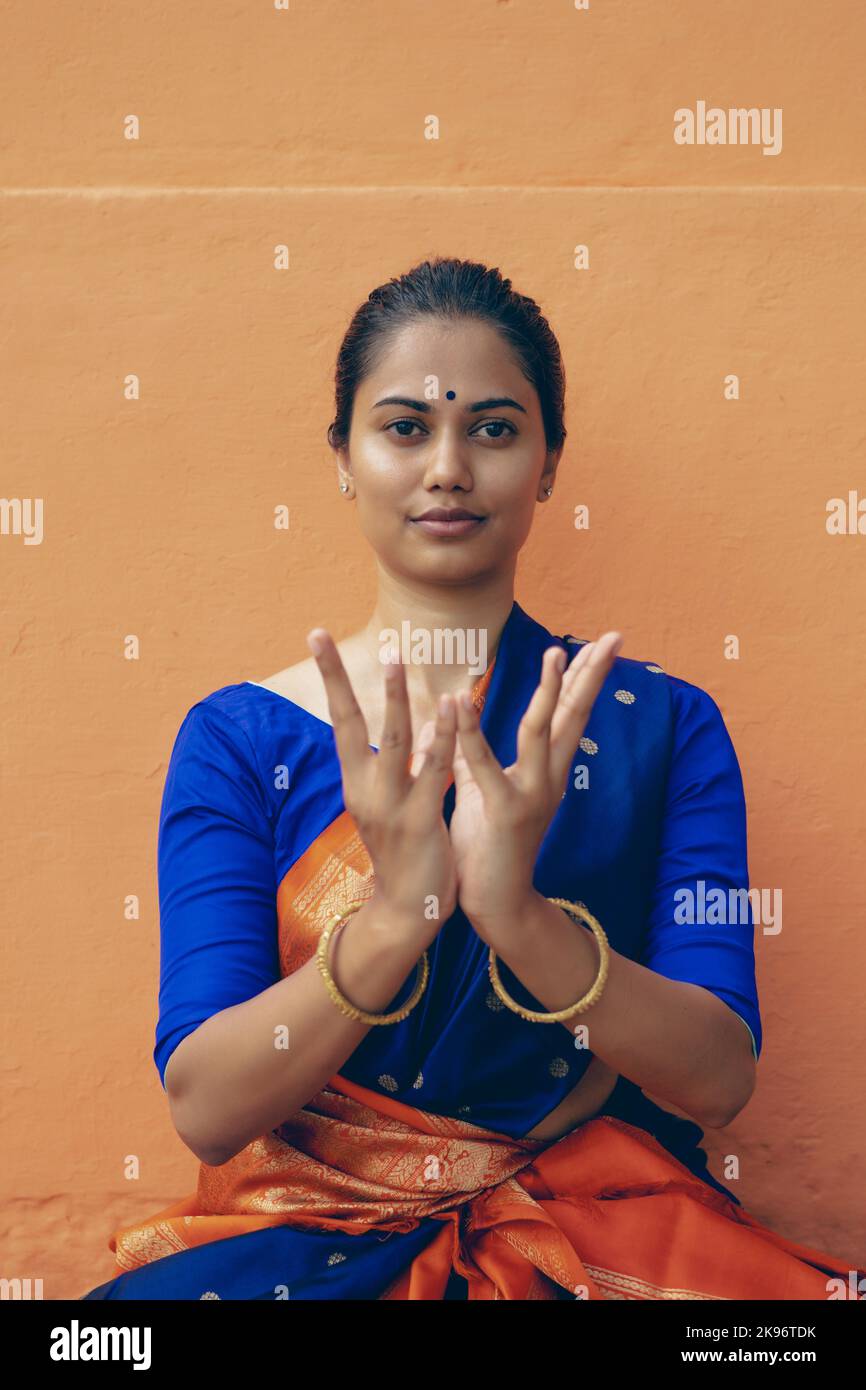 A portrait of a south Asian yogini in a sari doing asana in an ancient ...