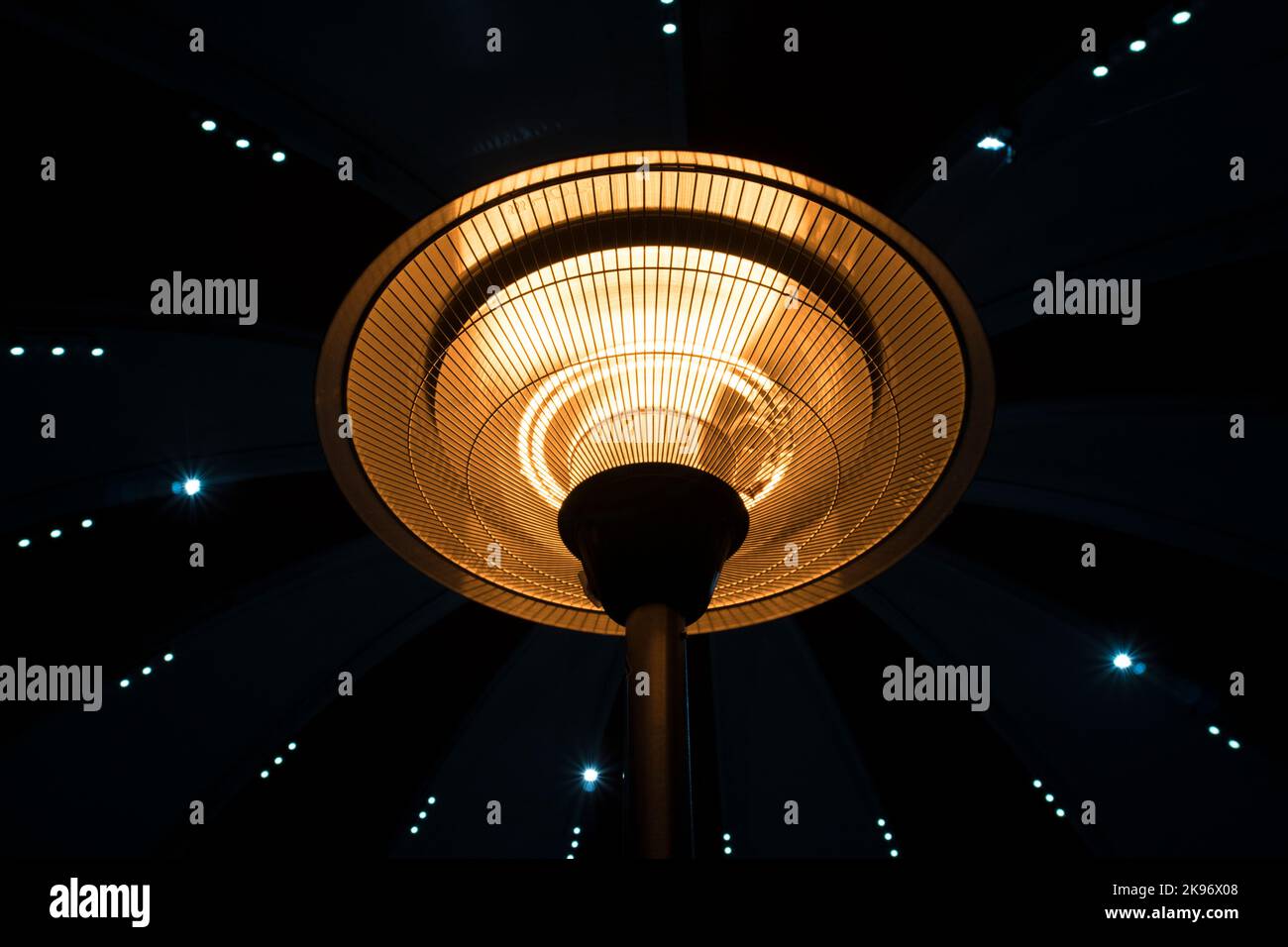 Infrared heater round shape on a black background in a large cold room ...