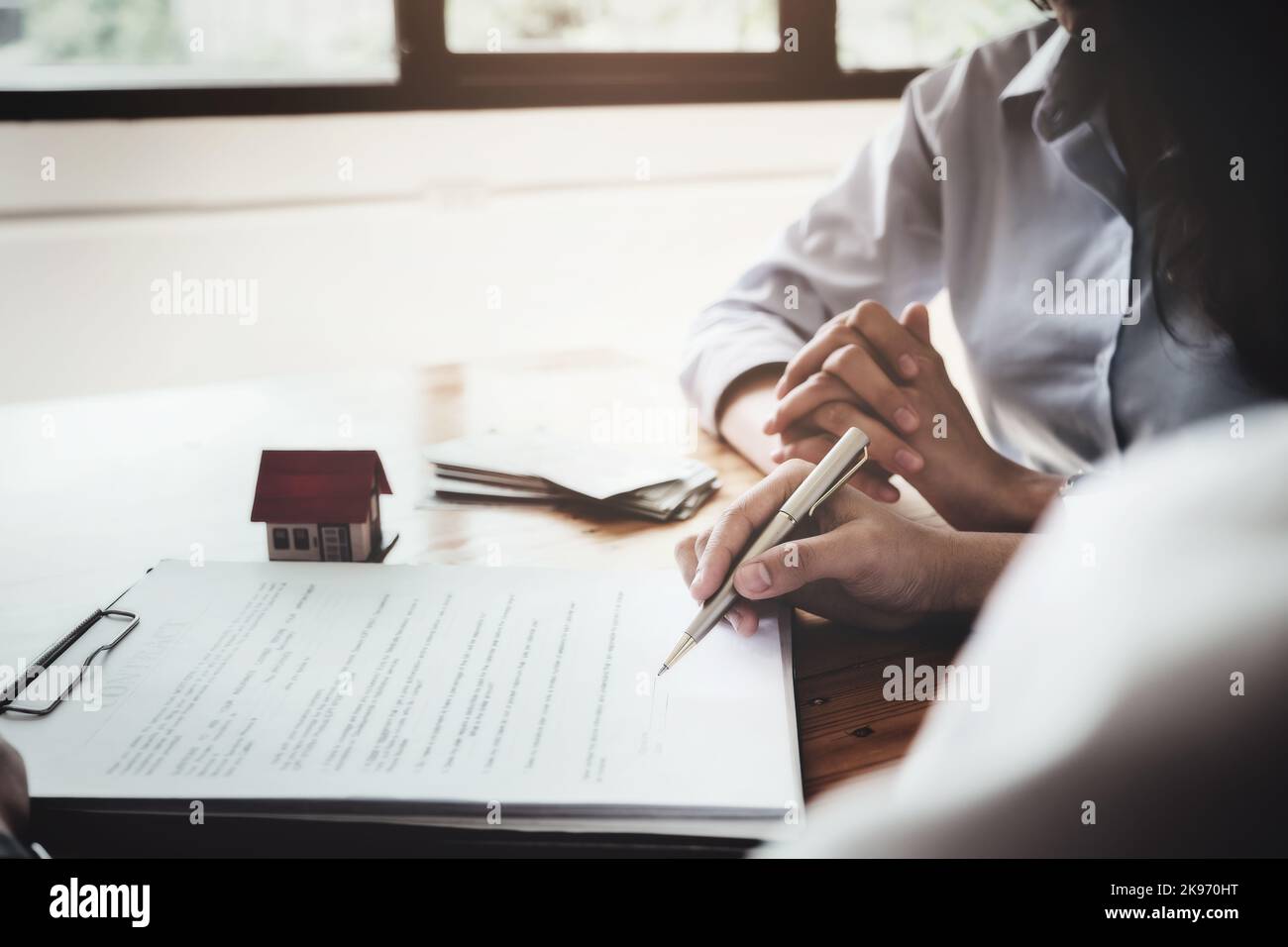 The customer holds a pen and reads the conditions in order to sign a ...