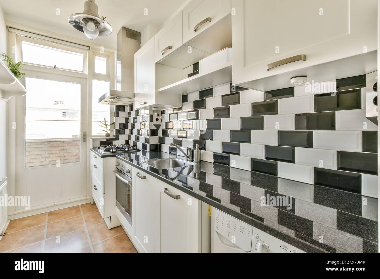 Interior of light kitchen with modern cupboards and appliances located ...