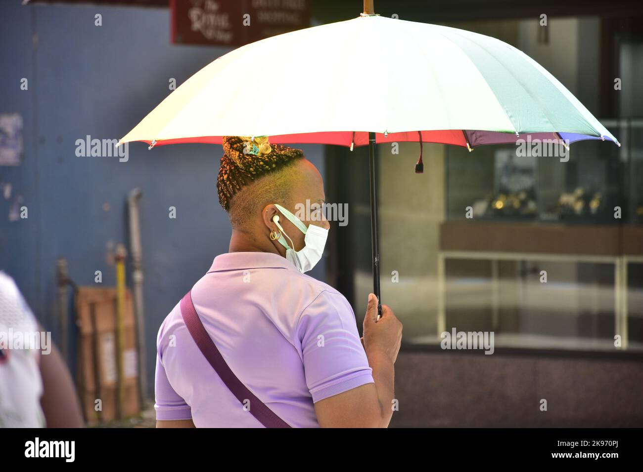Lady shading the sun with Umbrella on a hot day in Bridgetown Barbados ...