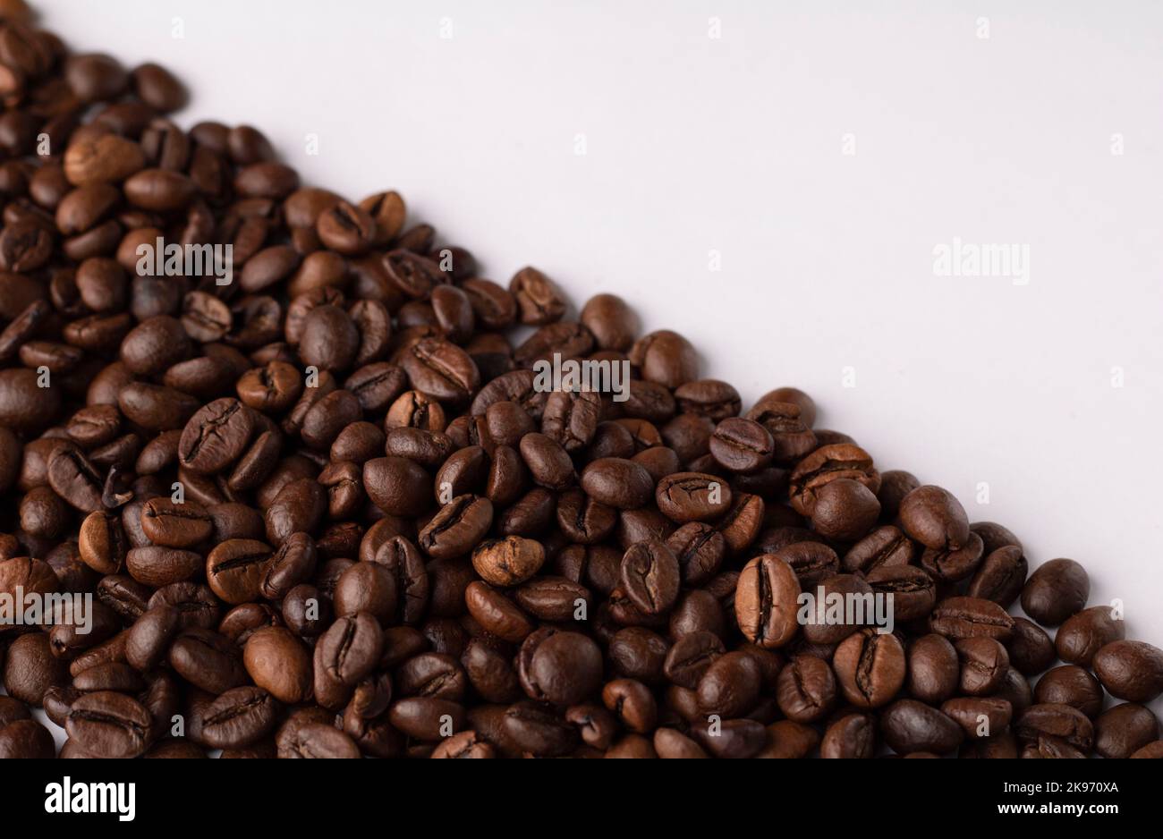 photo whole coffee beans lying on the side of the table on a white ...