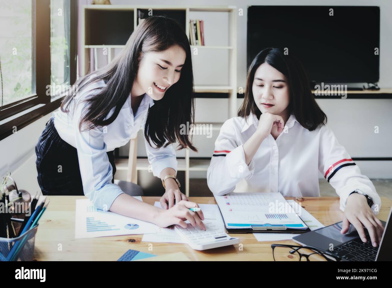 focus hand using calculator, Two young business executives are ...