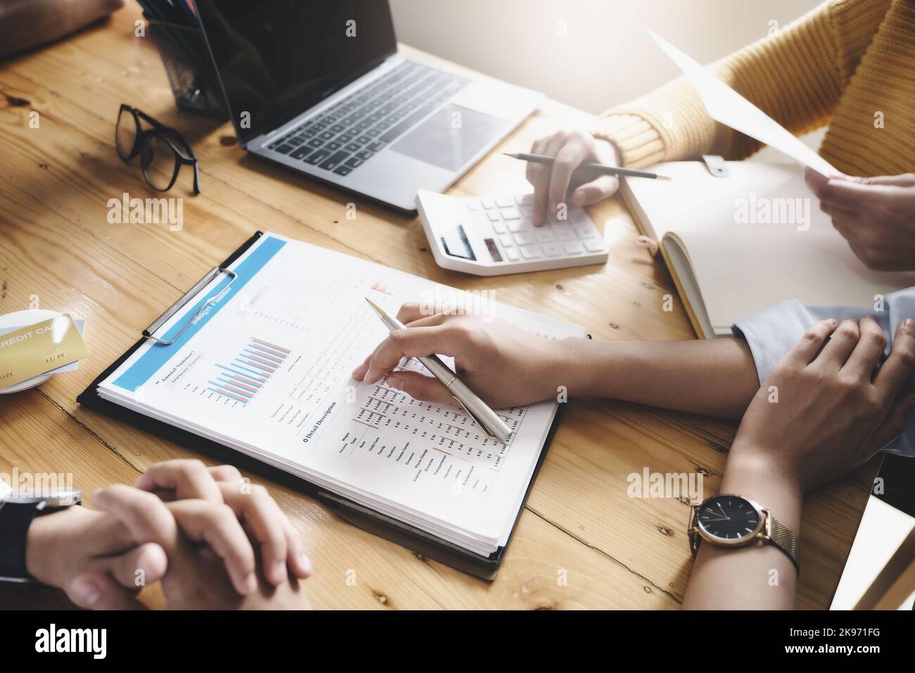 The auditor holds a pen pointing to the budget document to investigate ...