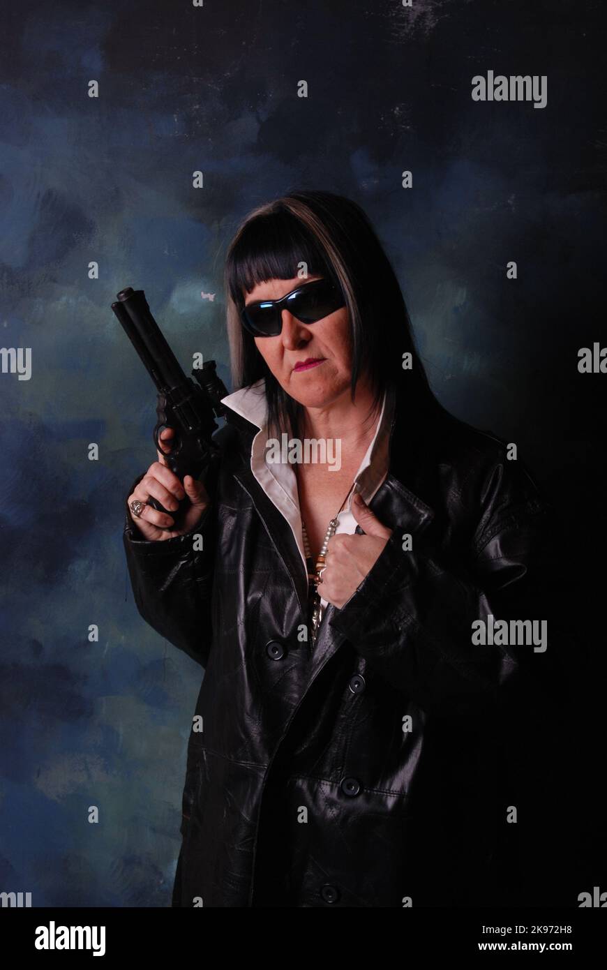 A vertical shot of an elderly secret agent spy woman in a leather ...