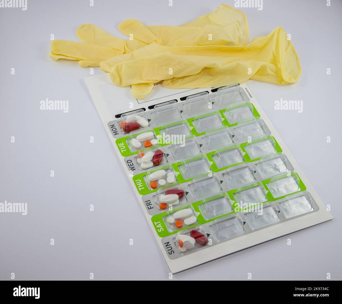 A closeup of medications webster pack and examination gloves PPE Stock ...