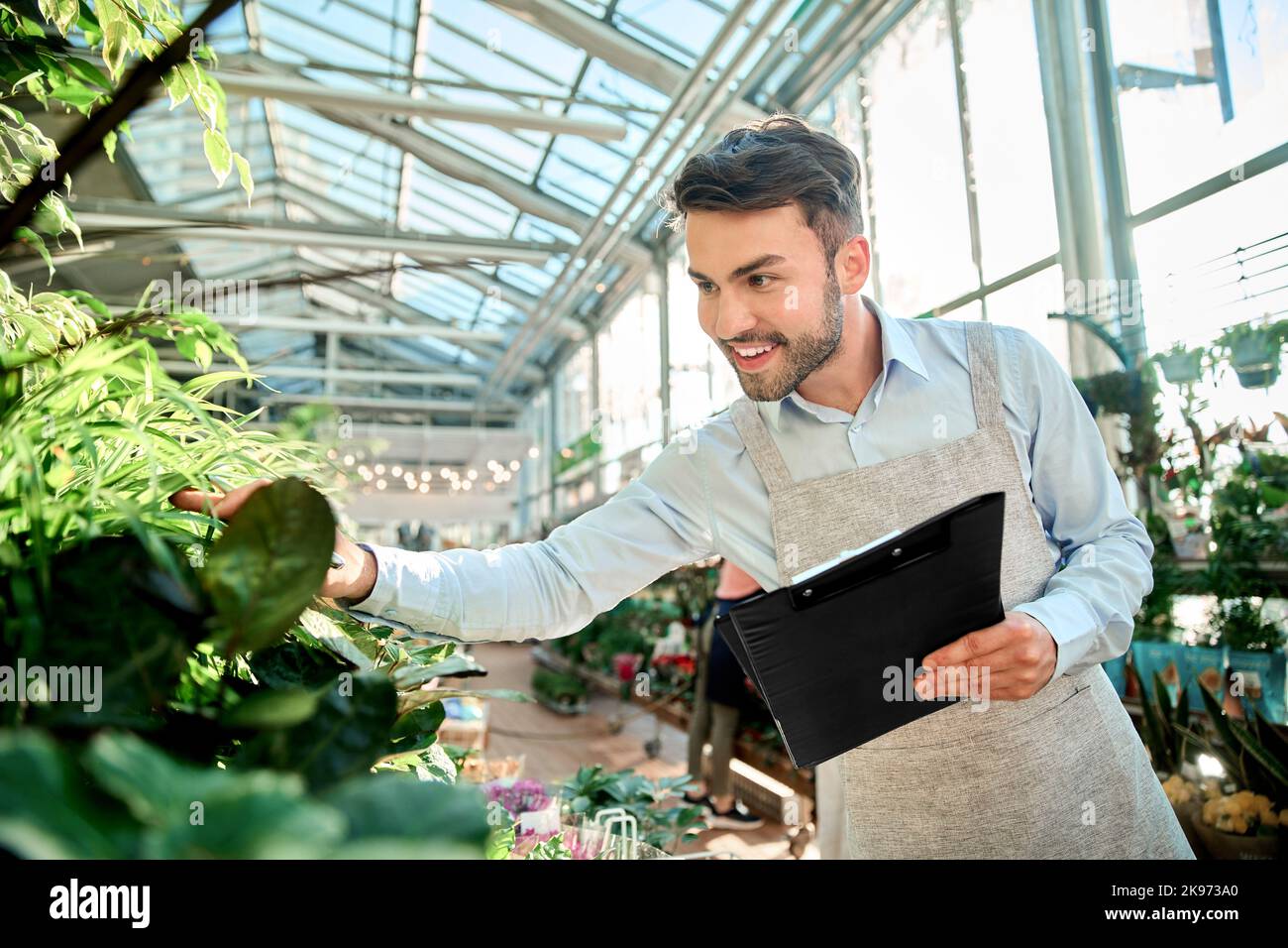 Florist man with clipboard at flower shop Stock Photo - Alamy