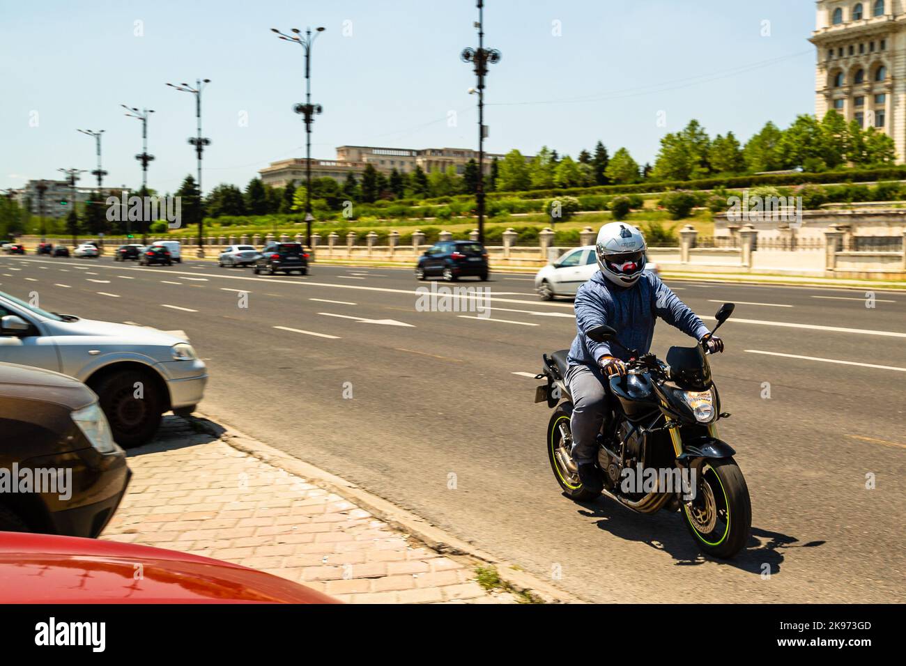 Biker on a motorcycle in traffic at rush hour in downtown area of the ...