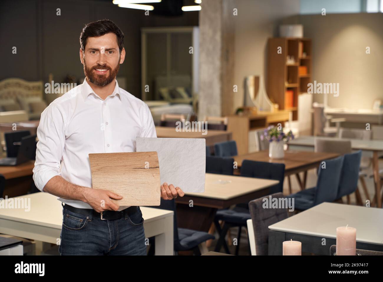 Confident male interior designer presenting wooden laminated samples ...