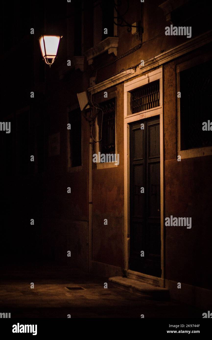 A door of a building in the night lit by a single street light Stock ...
