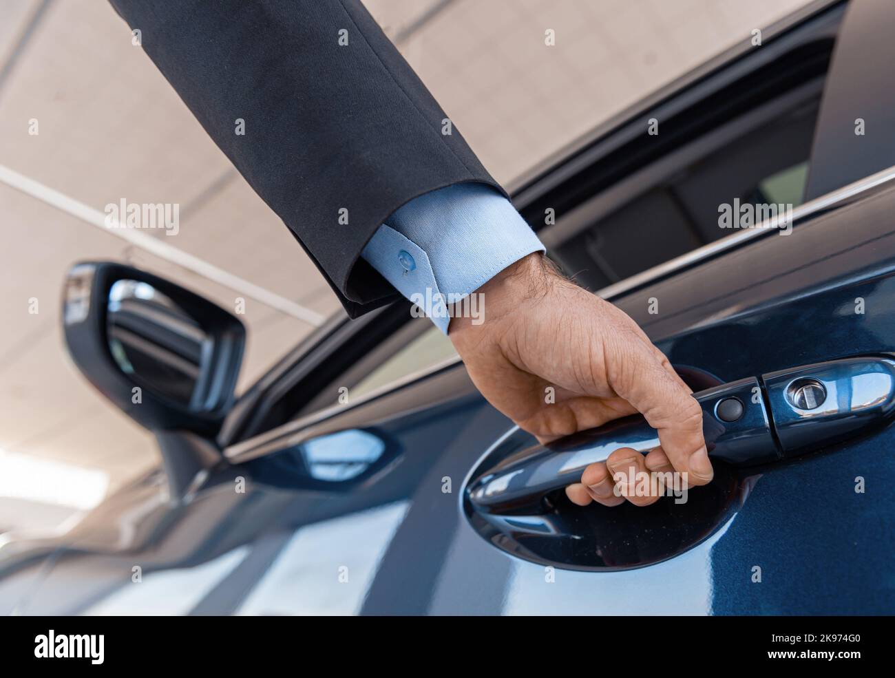 Close up of a male businessman hand opening a car door at the ...