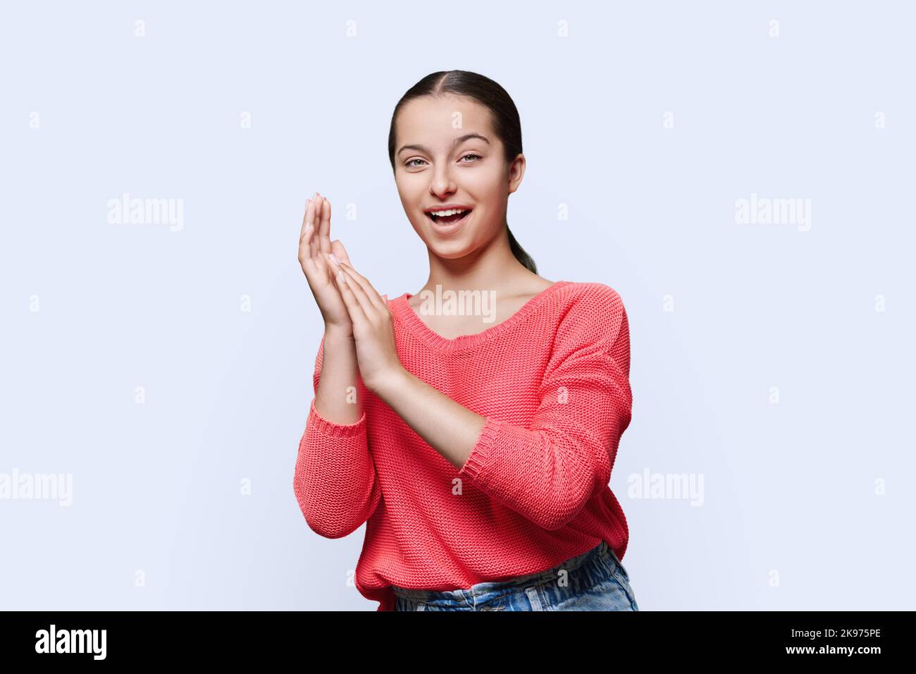 Young teenage girl clapping her hands on white studio background Stock ...