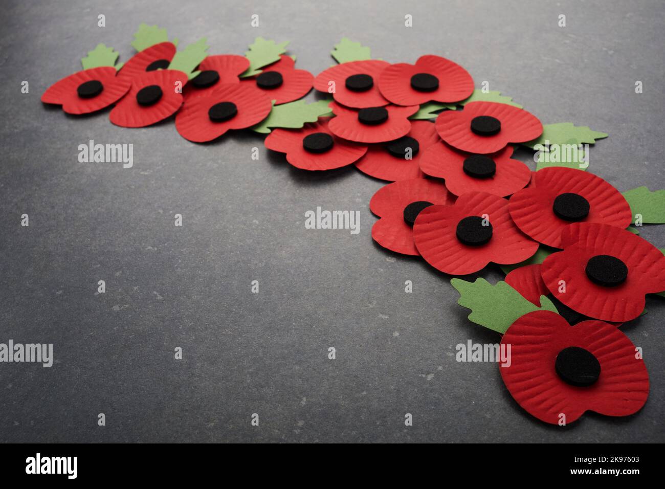 World War remembrance day. Red paper poppies on dark stone background ...