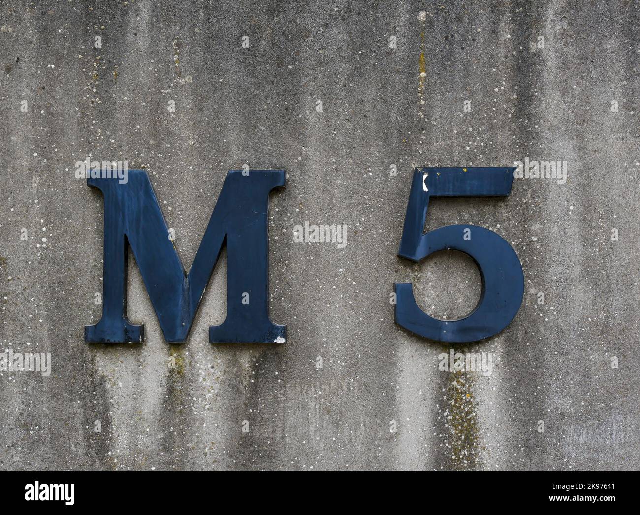 An old concrete wall attached with blue M5 letter Stock Photo - Alamy