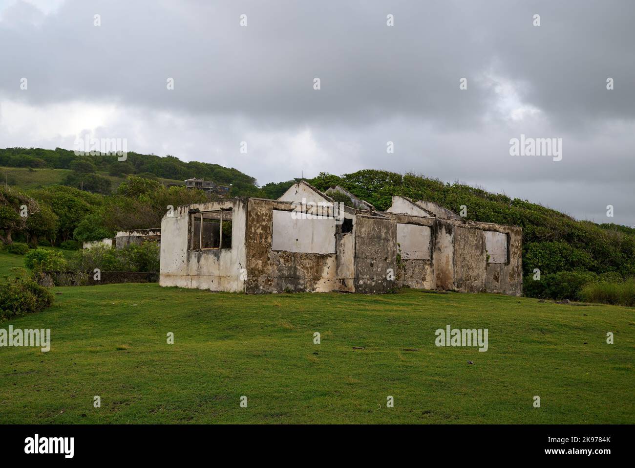 The ruins of an ancient stone building in a bright green field ...