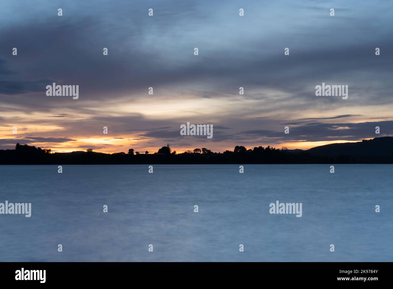 Tauranga Harbour sunrise deep sky colors above silhouette trees and ...