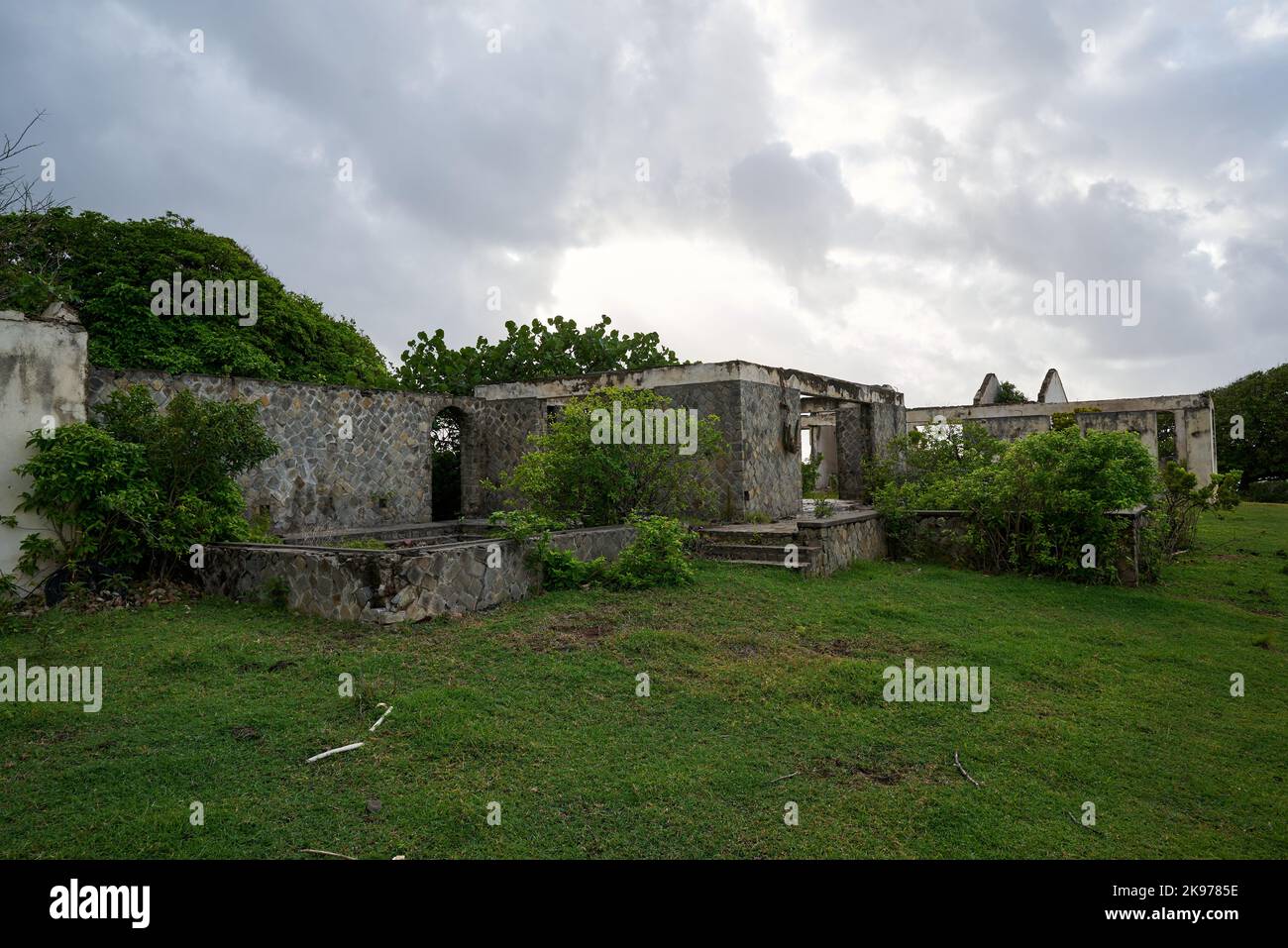 The ruins of an ancient stone building in a bright green field ...