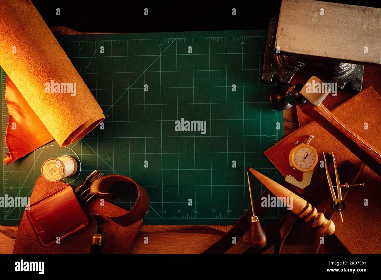 A closeup shot of thick leather sheets and tools for leathercraft on ...