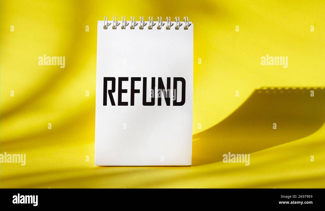 REFUND text written in notepad on yellow background Stock Photo - Alamy
