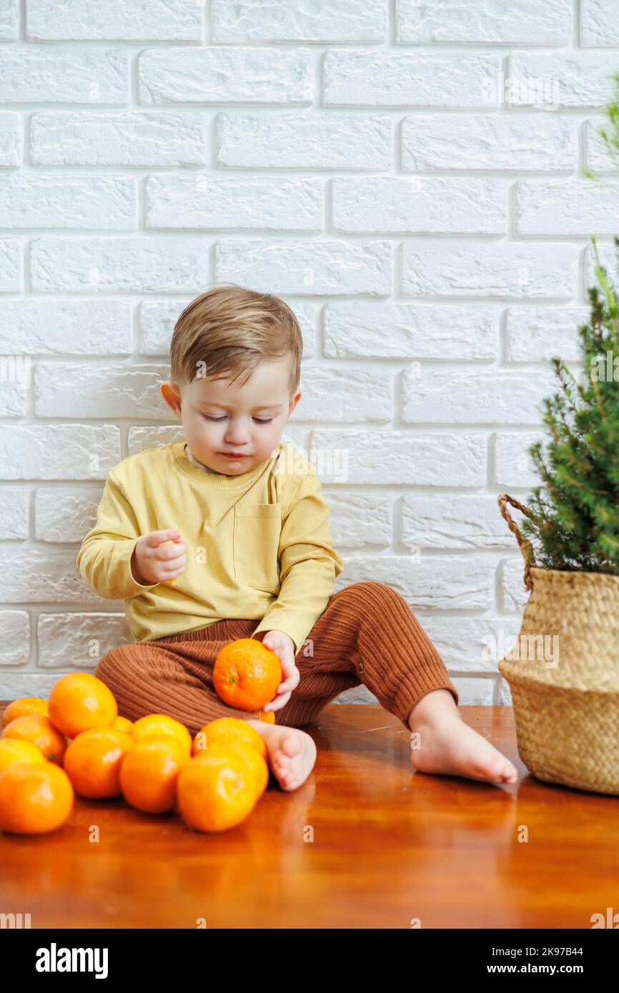 Cute smiling kid eating one fresh juicy tangerine Stock Photo - Alamy