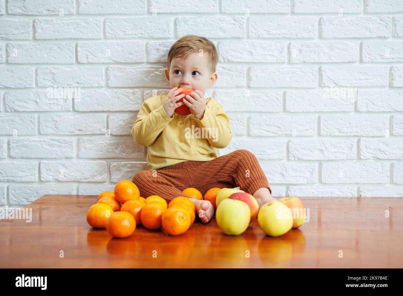 Cute smiling kid eating one fresh juicy red apple. Healthy fruits for ...