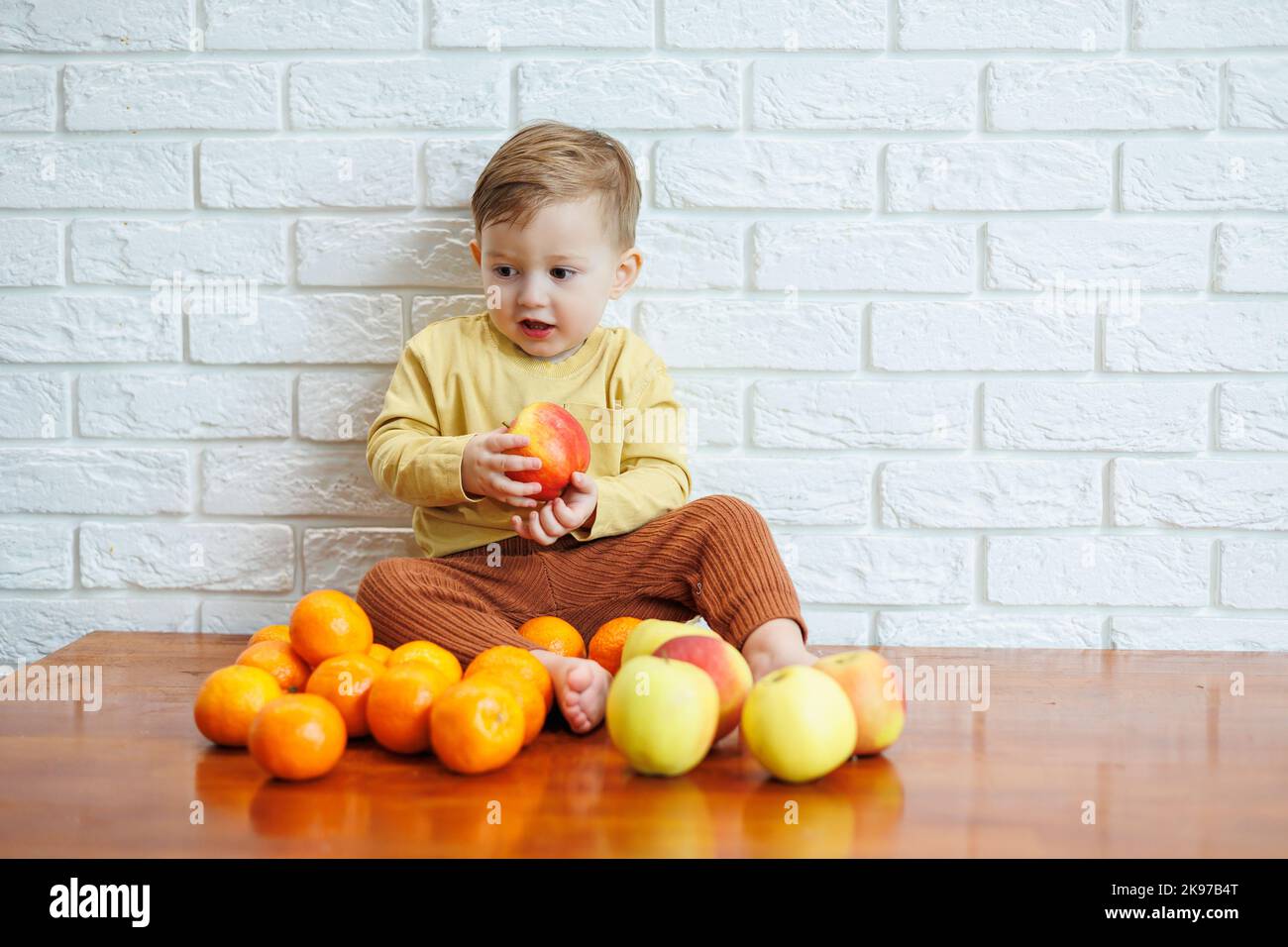 Cute smiling kid eating one fresh juicy red apple. Healthy fruits for ...