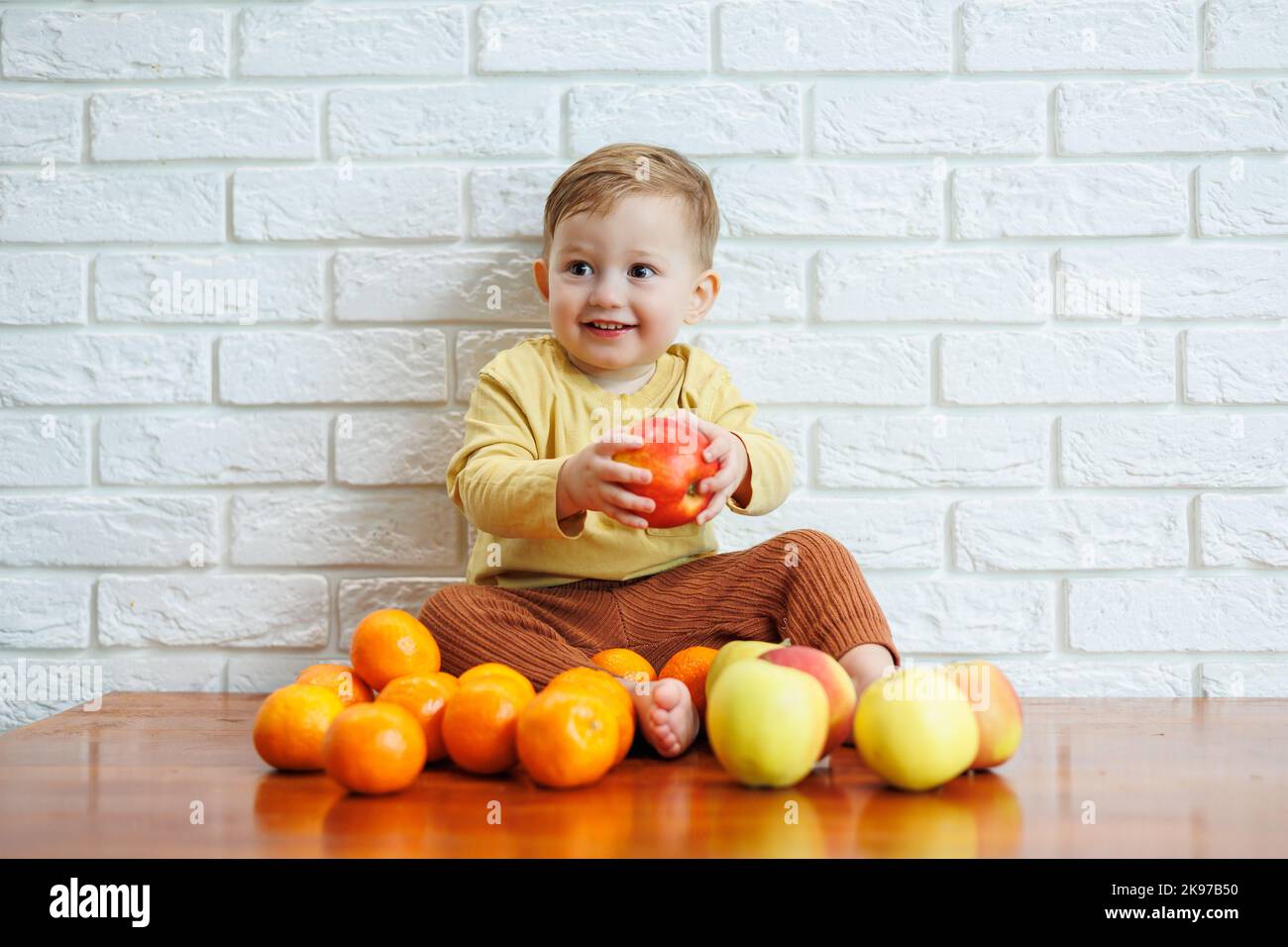 Cute smiling kid eating one fresh juicy red apple. Healthy fruits for ...