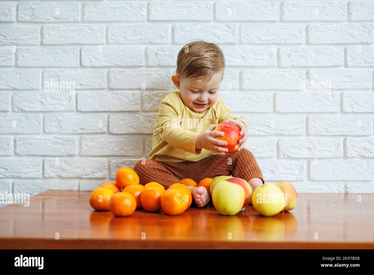 Cute smiling kid eating one fresh juicy red apple. Healthy fruits for ...