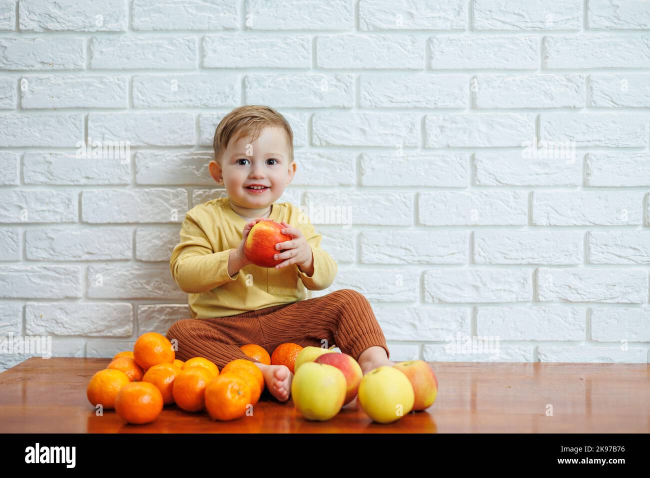 Cute smiling kid eating one fresh juicy red apple. Healthy fruits for ...