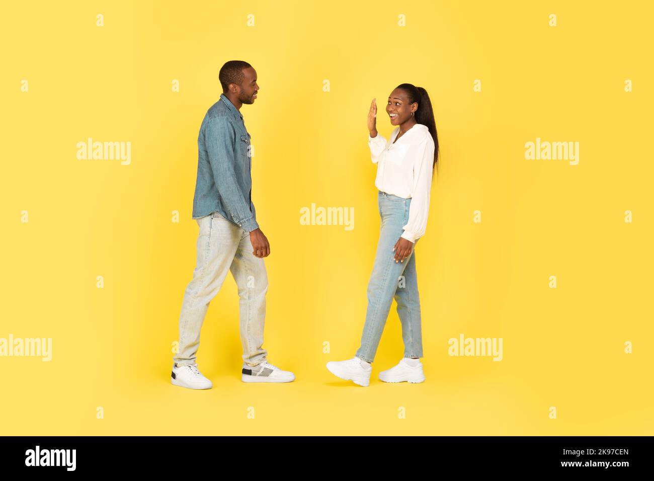 Cheerful Black Couple Walking Meeting Woman Waving Hand Yellow