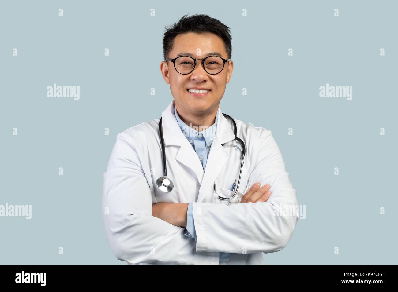 Cheerful middle aged chinese male doctor in white coat, glasses with ...