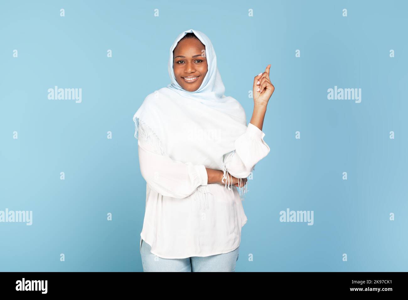 Happy black islamic lady in hijab pointing finger up, having ...