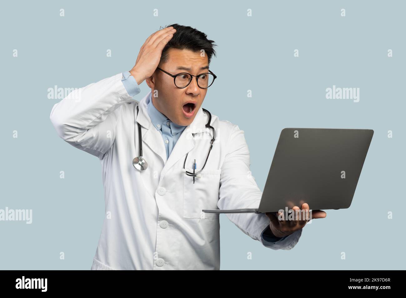Sad shocked mature chinese man doctor in white coat, glasses with ...